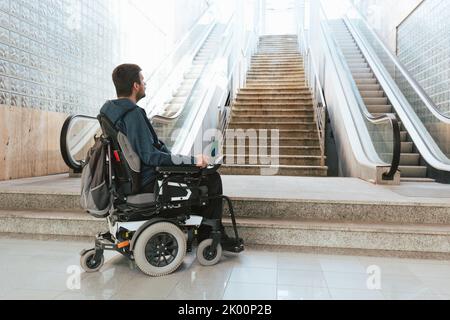 Man with disability on wheelchair stopped in front of staircase ...