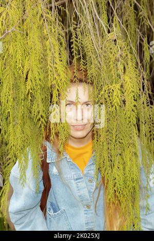 A woman hides spring in the garden. Cleans from old and withered twigs ...