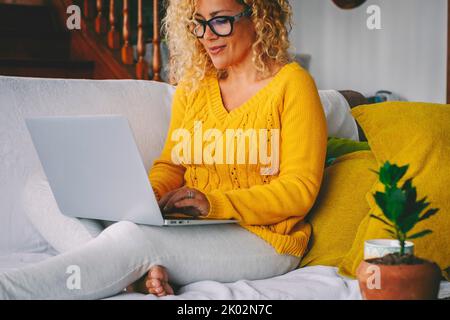 Middle age blonde woman ecommerce business worker unboxing package at ...