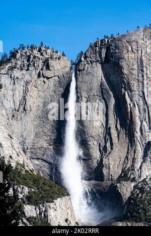 The vertical view of Yosemite falls under the blue sky on a sunny day ...