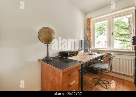 Comfortable chair placed near desk with computer monitors and ...