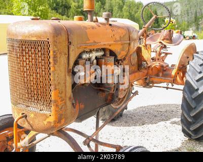 A selective focus of an old rusty tractor in a winter field with snow ...