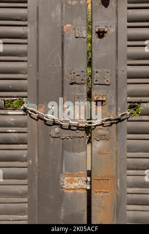 closeup of closed gates with massive metal steel rusty chains with big ...