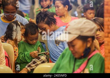 One Filipino child with a mobile phone whilst two others look on ...