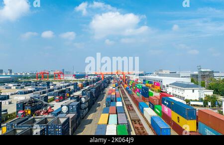 Workers operate heavy lifting equipment to lift containers at the Haian ...