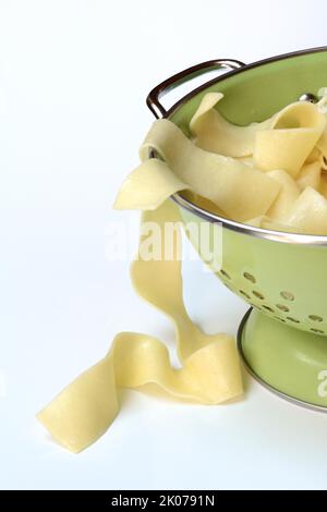 Pappardelle, cooked, wide Italian ribbon noodles in kitchen sieve ...