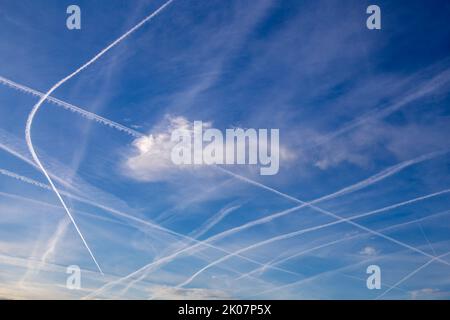 Blue sky with many contrails or chemtrails Stock Photo - Alamy