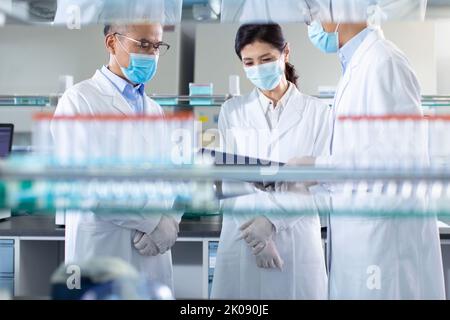 Three Chinese researchers discussing in laboratory Stock Photo - Alamy