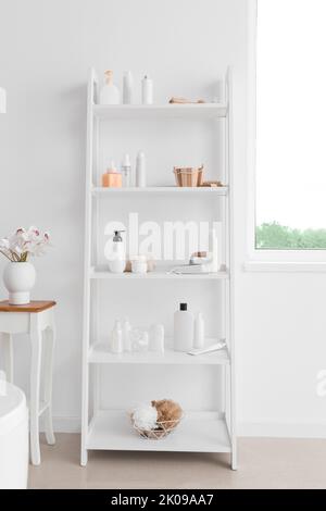 Different bath accessories on shelf unit near wooden wall, closeup ...