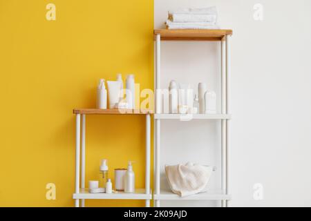 Shelf units with different bath accessories near color wall Stock Photo ...
