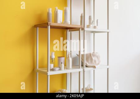 Shelf units with different bath accessories near color wall Stock Photo ...