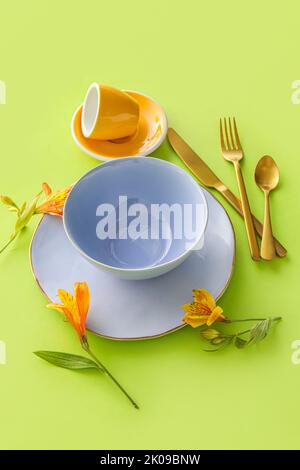 Table setting with beautiful alstroemeria flowers on blue background ...