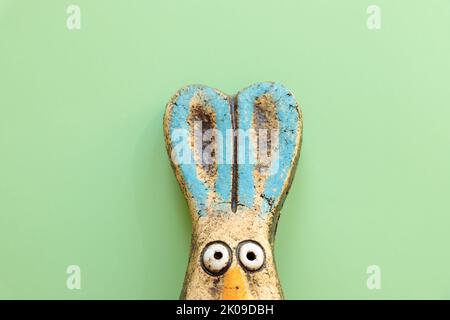 Shocked eyes and ears of toy hare on green background with copy space ...