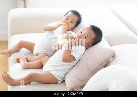 Cute Chinese twin babies drinking water from baby bottles Stock Photo ...
