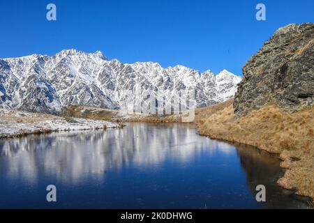 The Remarkables reflected in Summit Tarn Deer Park Heights near ...