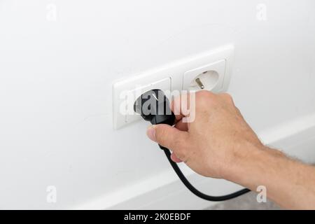 Saving energy at home, removing the plug from the socket Stock Photo ...