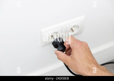 Saving energy at home, removing the plug from the socket Stock Photo ...