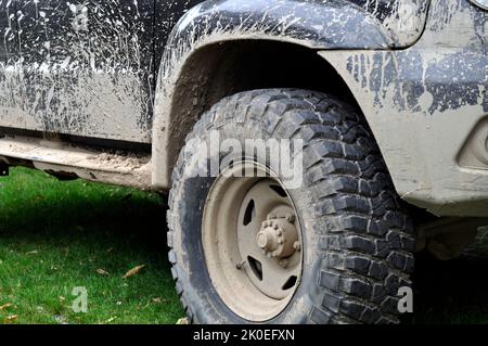 SUV covered in mud. The wheels and body of the car are splattered with ...