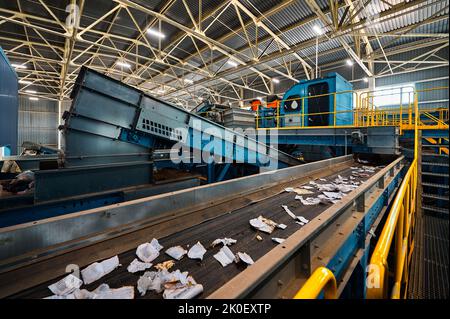 Conveyors carry trash and empty platforms at recycling plant Stock ...