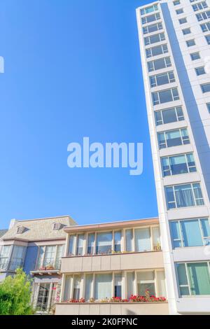 Multi-storey building with balconies and flowering trees in an urban ...