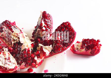 Pomegranate slices in plate on white background, top view with space ...