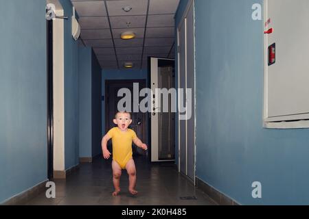 Toddler baby leaves the open door of the apartment. Child boy runs away ...