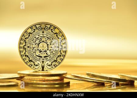 A closeup shot of Maya cryptocurrency coins on a golden background ...
