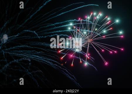 A burst of red and turquoise fireworks in the night sky Stock Photo - Alamy