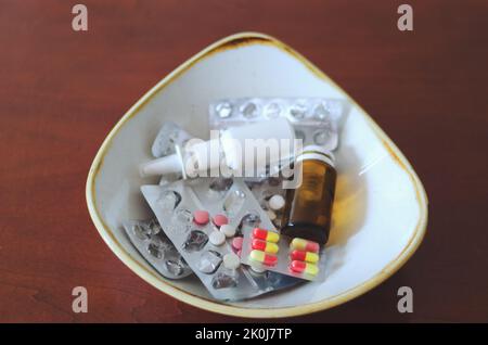 Many pills, drops in the nose, packages and blisters with pills lie in ...