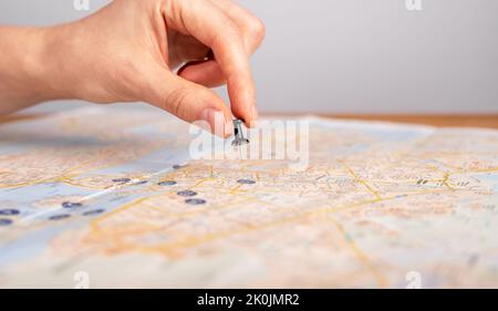 Hand pushing pin on map. Trip planning. Woman marking travel ...