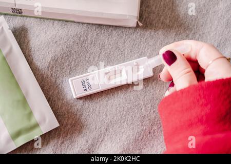 A covid swab sample in buffer solution is dropped onto the test ...