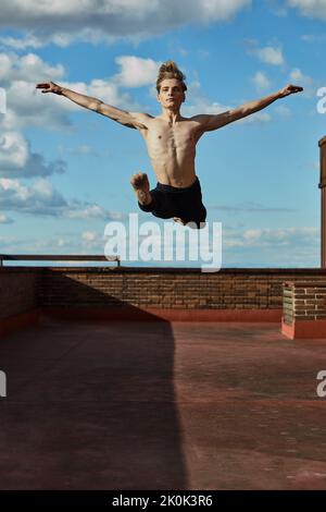 Masterful young blond ballet dancer in black leotard performing ...