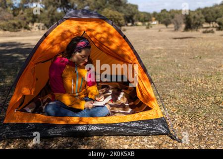 Focused Young Woman Writing In Notebook At Home Office With Laptop ...
