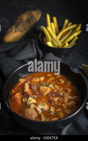 From above of tasty callos a la madrilena in black bowl near French ...