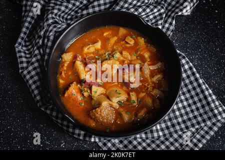 From above of tasty callos a la madrilena in black bowl near French ...