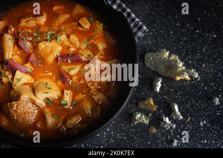 From above of tasty callos a la madrilena in black bowl near French ...