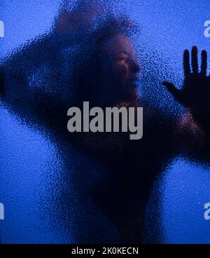 Shadow of woman screaming behind the glass, domestic violence concept ...