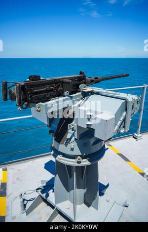 Color image of an automated machine gun on the deck of a military ship ...