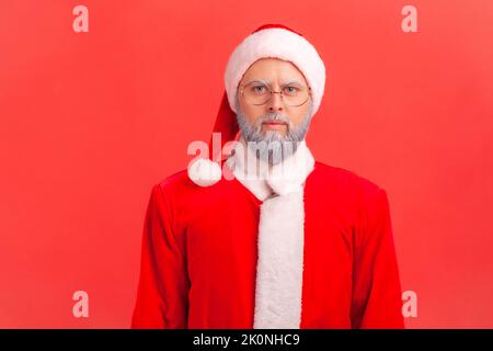 Santa Claus with serious face on red holiday garlands background Stock ...