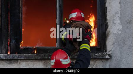 Firefighter hero carrying baby girl out from burning building area from ...