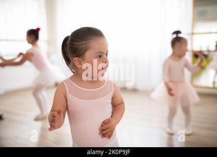 Little girl with down syndrome at ballet class in dance studio. Concept ...