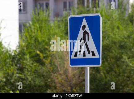 Pedestrian triangle road sign blue background Stock Photo - Alamy