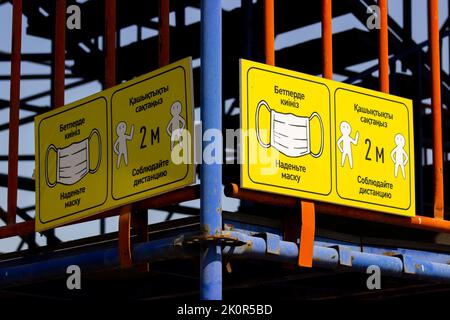 Keep distance wear the mask yellow information sign Stock Photo - Alamy
