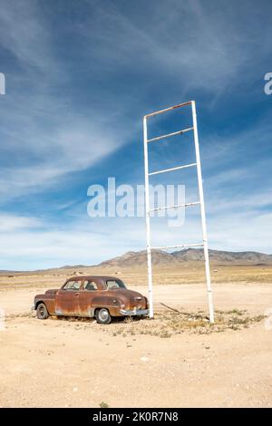 old rotten vintage car at a patrol station in the desert at Route 895 ...