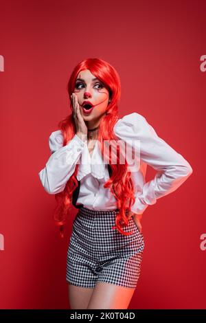 woman in a halloween clown costume over isolated black background ...