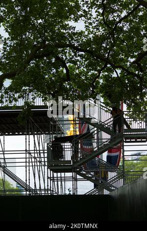Temporary structures and workers are silhouetted against the Victoria ...