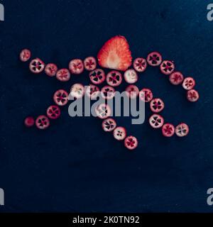 octopus made from red fruits on black background Stock Photo - Alamy
