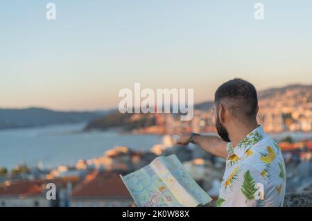 Tourist man viewing a map while visiting a coastal european city Stock ...