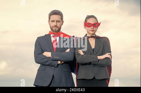 business couple in superhero suit on sky background. copy space ...
