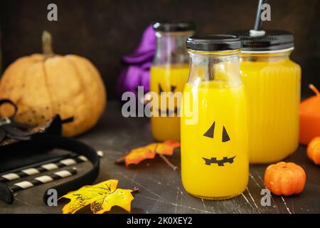 Halloween mocktails. Pumpkin cocktails and lemonade in glass jars ...